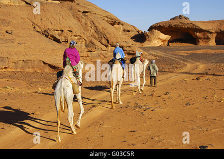 Tourists riding on Mehari camels of the Tuareg nomads passing through ...