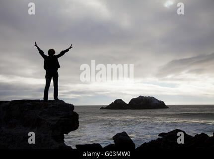 Silhouette of a woman praying at sunset, expressing faith, hope, and ...