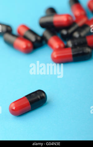 Selective focus of red and black capsule pills on stainless steel drug ...