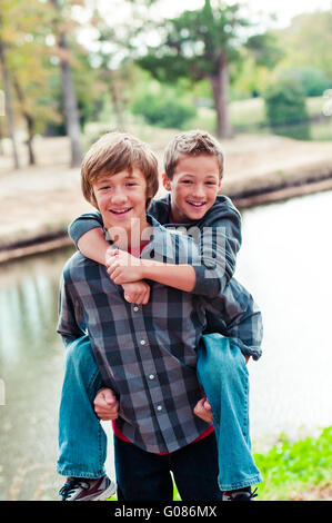 Two young boys piggy back Stock Photo - Alamy