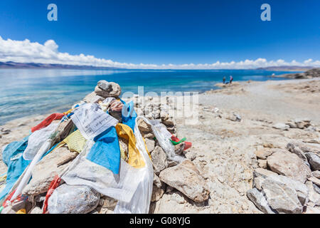 Marnyi stone with sutra streamers on the lakeside of Namtso, Tibet ...