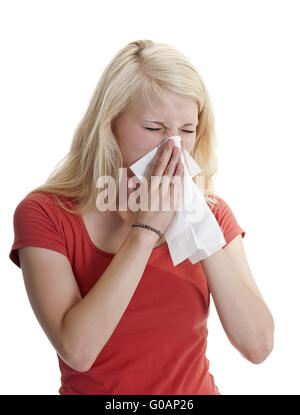 A beautiful woman with a cold, hay fever or allergies blowing her nose ...