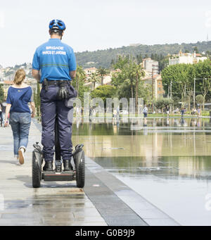 On Segway, a male security guard in bright yellow coat anorak looks at ...