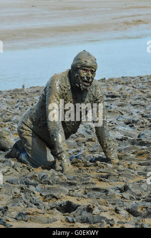 A man crawls through mud during a muddy obstacle event in Leeds Stock ...