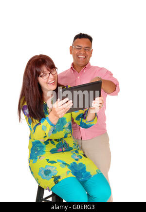 Hispanic middle age couple at home, woman using laptop showing and ...