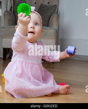 Adorable caucasian girl playing with play kitchen standing at ...