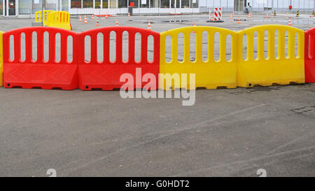 The safety water-filled plastic barriers and a triangle traffic cone ...