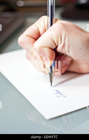 Woman's hand with a pen writing on the business paper. Report chart ...