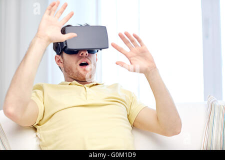 Scared young man playing game in virtual reality glasses Stock Photo ...