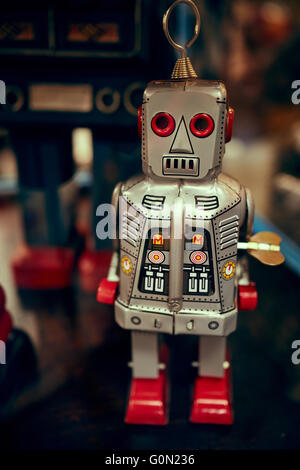 A vintage clockwork wind-up tin toy depicting an old blue car ...