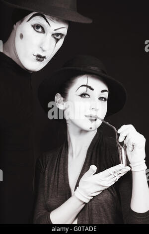Portrait of two mimes in hats on black background Stock Photo - Alamy