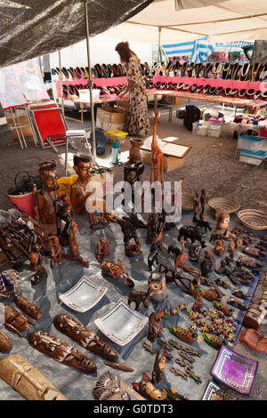 Outdoor market stall selling African goods and wood carvings ...