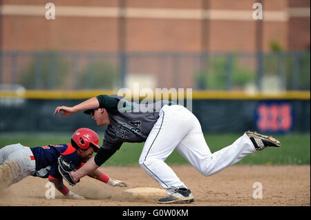 Base runner diving back into first base on an attempted pick-off play ...