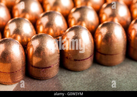 bullets on camouflage background spill out of the banks on camouflage ...