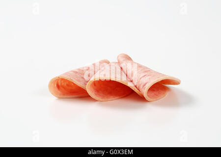 Thin slices of cured ham arranged on wooden board with fresh tomatoes ...