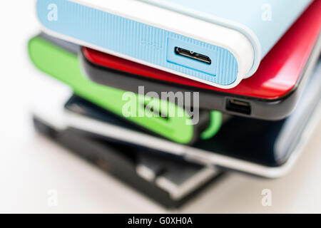 Stack of five different types of portable external hard drives with USB ...