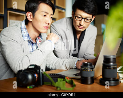 Two photographers working in studio with computer Stock Photo - Alamy