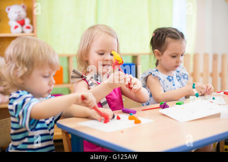 Kids group making arts and crafts in kindergarten or daycare center ...
