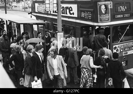 Archive image of a bus queue at a bus stop on a rainy day in Lambeth ...