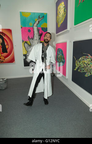 Adrien Brody poses in front of his paintings during preview at Art New ...