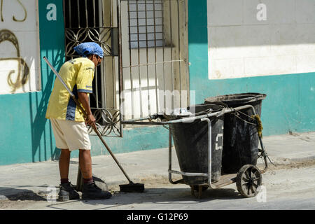 female street cleaner brushing streets with broom early morning in lan ...