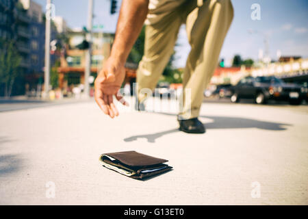 man finding a wallet lost on the ground and picking it up Stock Photo ...