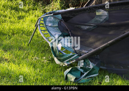 Storm damaged trampoline on green reserve alongside freeway barrier ...