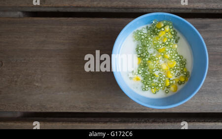 Tapioca pudding or Sakoo (Thai dessert) with coconut milk on wood table ...