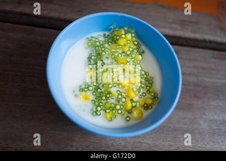 Tapioca pudding or Sakoo (Thai dessert) with coconut milk on wood table ...
