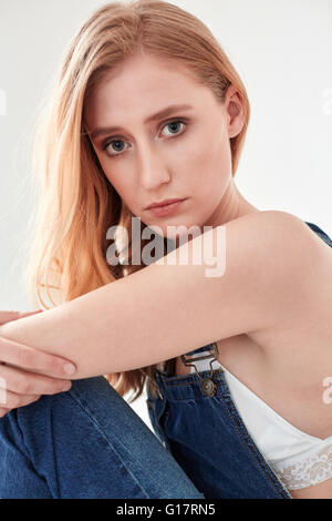 Portrait of aloof woman staring at camera with blank facial expression ...