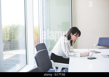 The businesswoman writing notes at desk Stock Photo - Alamy