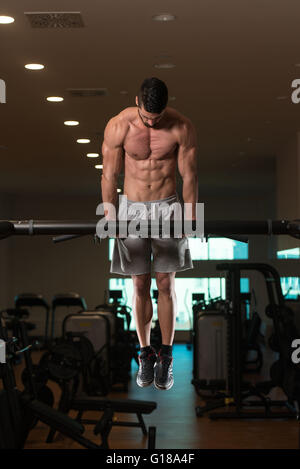 Young Bodybuilder Doing Dips on Bar Exercising Triceps On Machine In ...
