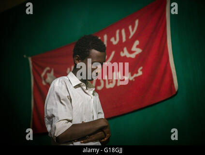 Sufi man worshipper in front of islamic red flag, Harari region, Harar ...