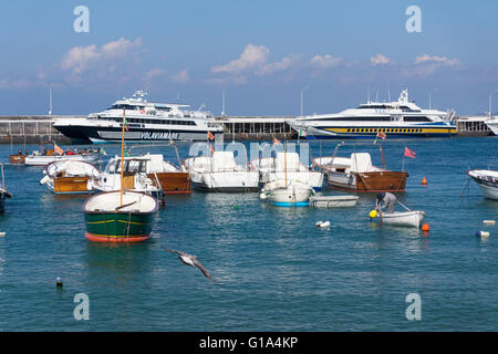 Small dinghies and large boats moored, including ferries to the ...