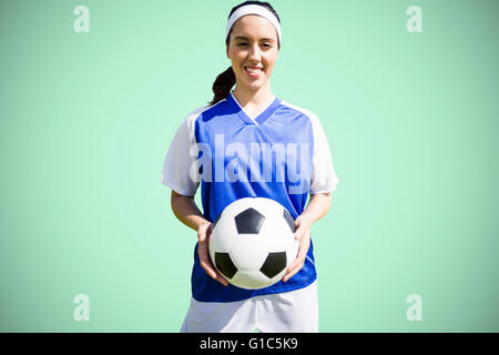 Composite image of woman holding soccer ball Stock Photo - Alamy