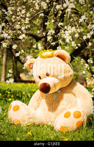 big teddy bear sitting under blowing trees Stock Photo - Alamy