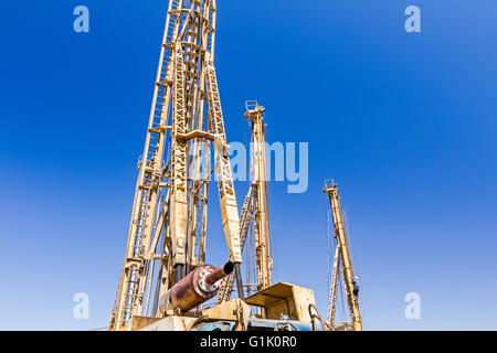 Towers of drilling machines are standing tall high at blue sky in the ...