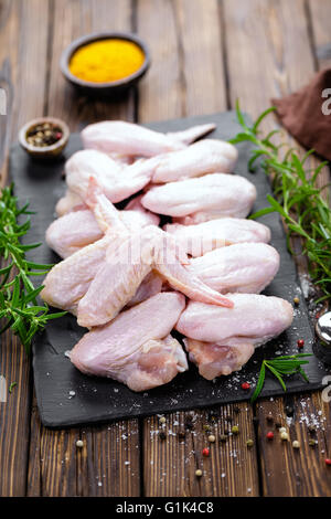 Raw chicken wings with bone and skin on wooden cutting board. Photo ...