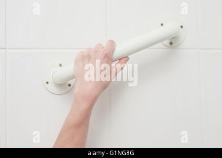 A young female hand is grabbing the handle of a big blue door outside ...