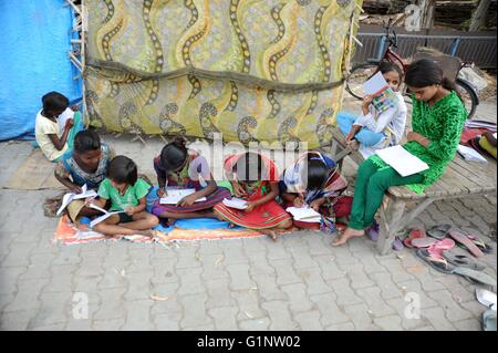 Child of slum area reading at a road side school in Allahabad. (Photo ...