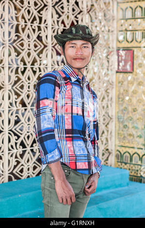 Cool looking, young Burmese man with earphones, dyed hair and stylish ...
