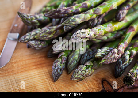Wooden board with fresh green asparagus and different ingredients on ...