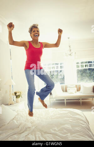 Mixed race woman jumping on the beach Stock Photo - Alamy