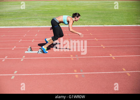 Female athlete running from starting blocks Stock Photo - Alamy