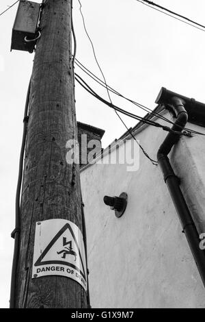 Old wooden telegraph pole seen next to a cottage showing a standard ...
