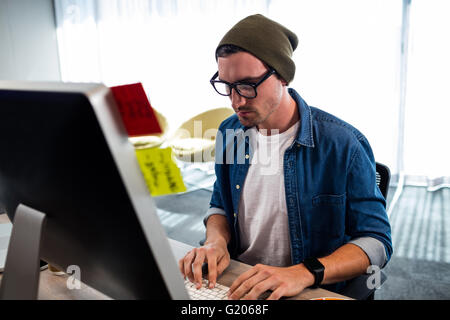 Portrait of serious hipster man working at computer desk Stock Photo ...