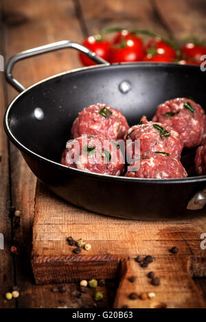 Raw meatballs on wooden cutting board ready for cooking. Composition ...
