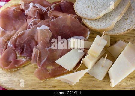 Slices of luxury Parma ham with Parmiggiano Reggiano cheese, as typical ...