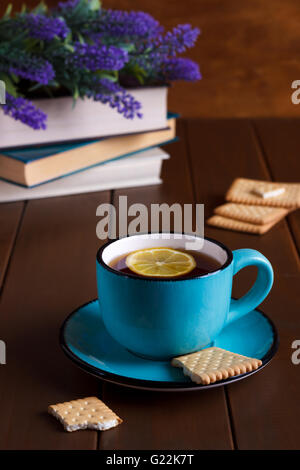 book, lemon, tea and cookies on table at home Stock Photo - Alamy