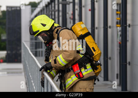 Firefighter wearing breathing apparatus ties a line from an external ...